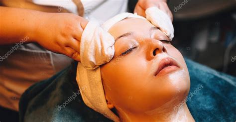 Mujer caucásica tumbada en el sofá en un salón de spa con un masaje