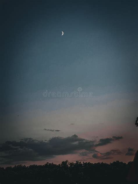 Crescent Moon Over A Serene Evening Sky With Fading Light Stock Image