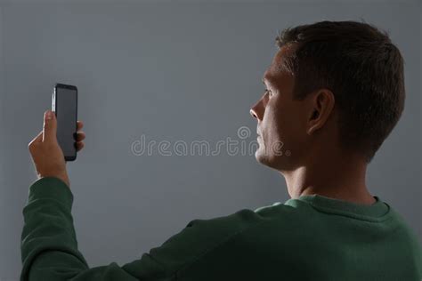 Man Unlocking Smartphone With Facial Scanner On Grey Background Biometric Verification Stock