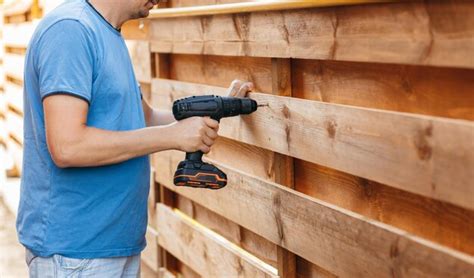 Premium Photo Adult Man Assembling A Modern Wooden Fence