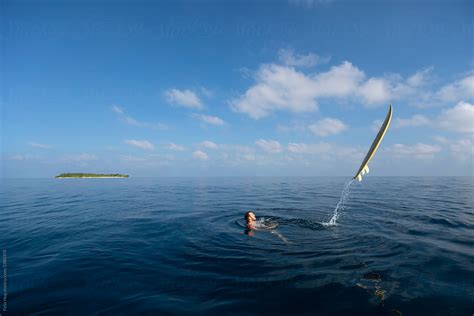 A Man In The Ocean With His Surfboard In The Maldives The Board Is