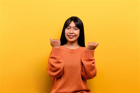 아시아 소녀 예쁜 오렌지 캐주얼 드레스를 입고 노란 배경은 행복한 미소와 승자의 표정으로 승리를 축하합니다 행복한 표현 건강한