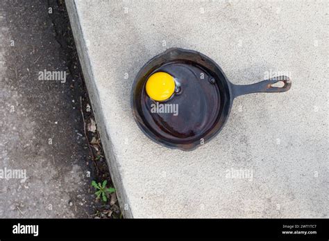 Raw Egg In A Frying Pan On The Hot Asphalt Road Fried Food On The