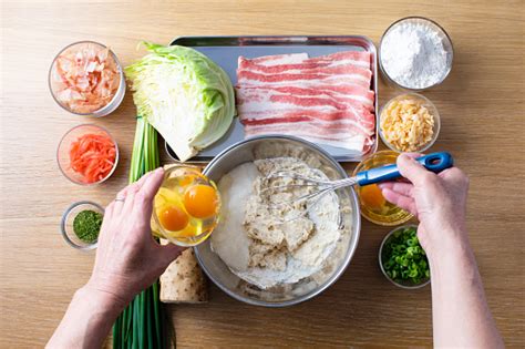 일본식 오코노미야키 레시피 참마 밀가루 양배추 돼지고기 텐카스 계란 붉은 생강 카츠부시 푸른 해초 파의 성분이 나뭇결 탁자 위에