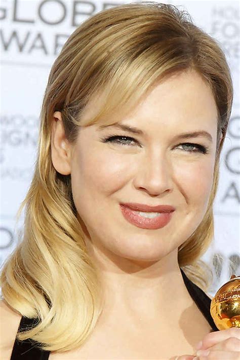 A Beautiful Blonde Woman Holding An Award In Her Right Hand And Smiling