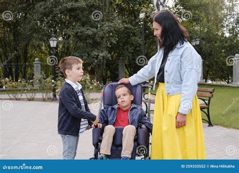 Familia Con Un Hijo Que Tiene Parálisis Cerebral En Silla De Ruedas Con Hermano De Madre Foto de