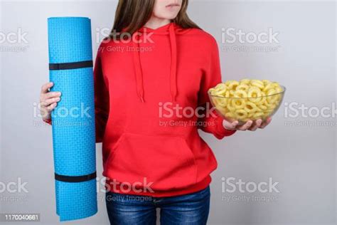 정크 푸드 고립 된 회색 배경과 큰 큰 접시를 들고 손에 두 가지 방법을 무게 측면을 찾고 혼란 숙고의 자른 클로즈업 사진