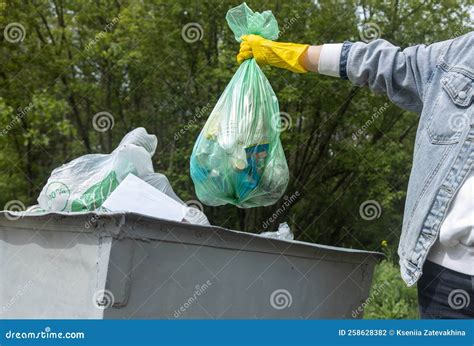 Throwing Garbage Into A Trash Can Close Up Of A Hand Holding A Garbage