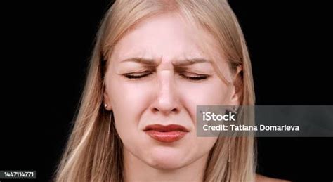 슬픔이나 상실을 경험하는 젊은 우는 여자의 얼굴 사진 상심과 감긴 눈의 찡그린 얼굴 검은 배경에 여자 소녀는 심한 스트레스를