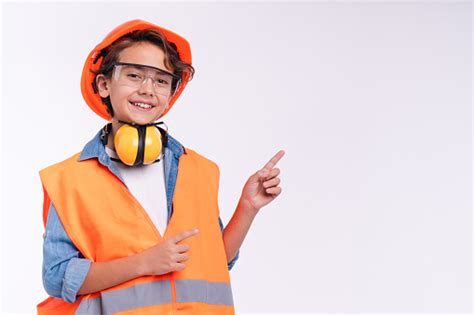 흰색 배경 위에 고립 된 복사 공간을 가리키는 유니폼을 입은 작은 백인 소년 건설 노동자 10 11세에 대한 스톡 사진 및 기타 이미지 10 11세 가리키기 건설