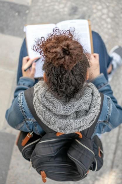 Premium Photo A Woman Sitting On The Ground Reading A Book