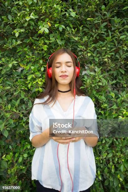 예쁜 패션 멋진 소녀 관목 배경에 빨간 헤드폰에서 음악을 듣고 갈색 머리에 대한 스톡 사진 및 기타 이미지 갈색 머리 낮 녹색 Istock