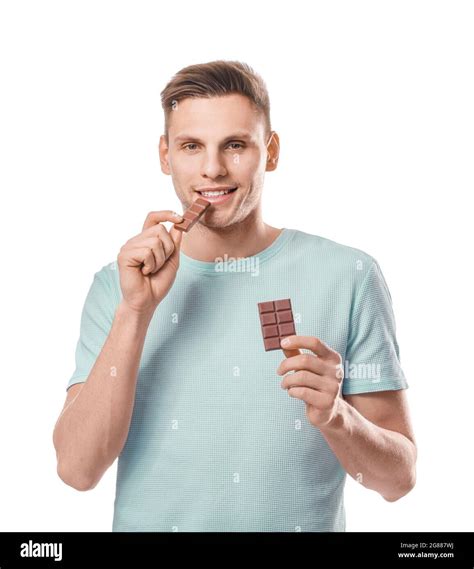 Handsome Young Man Eating Tasty Chocolate On White Background Stock