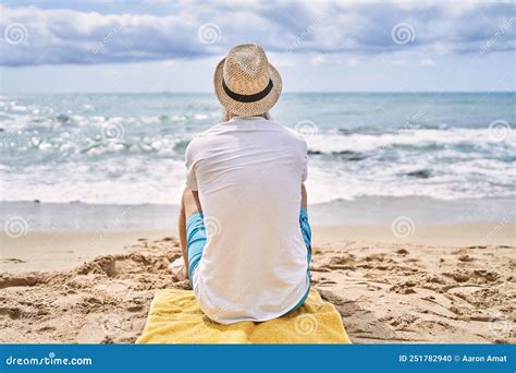 Young Redhead Tourist Man On Back View Sitting On The Towel At The
