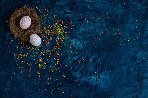 둥지에 두 개의 부활절 달걀과 파란색 배경에 과자의 화려한 장식 플레어 효과를 추가했습니다 공간을 복사합니다 플랫 레이 상단 보기 갈색에 대한 스톡 사진 및 기타 이미지