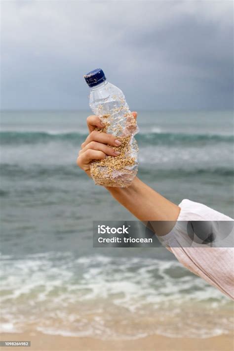 푸른 하늘 배경 손에 플라스틱 병 우리의 해변에서 쓰레기를 수집 하는 동작 바다 쓰레기 없는 개념입니다 일회용 플라스틱은 우리의 계획을 파괴 하는 인간의 중독 가방에 대한