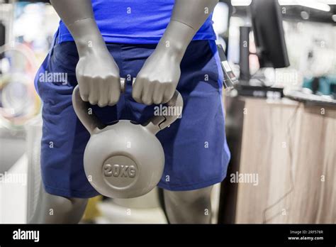 Dark Skinned Sports Mannequin Holds A Kettlebell With Two Hands