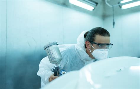 자동차 스프레이 룸의 자동차 정비사 안료가 완전하고 아름답고 자동차의 원래 색상과 조화를 이루는 자동차 앞 범퍼에 뿌려진