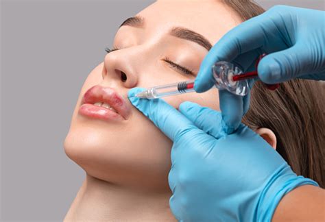 미용사는 아름다운 여성의 얼굴에 입술 확대 주름 방지 주사를 주사합니다 뷰티 살롱에서 여성 미용 화장품 Platelet Rich