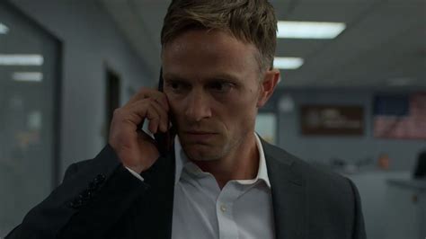 A Man Talking On A Cell Phone In An Office Building While Wearing A