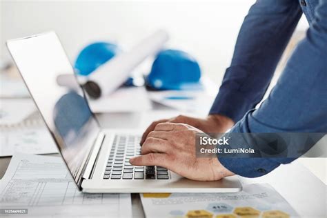 사무실에서 건설 설계 작업을 수행하는 노트북에 타이핑하는 건축가 엔지니어 또는 사업가 컴퓨터 앱 또는 웹 사이트를 사용하여 계획을 그리는 건물 계획자의 근접 촬영 손 웹