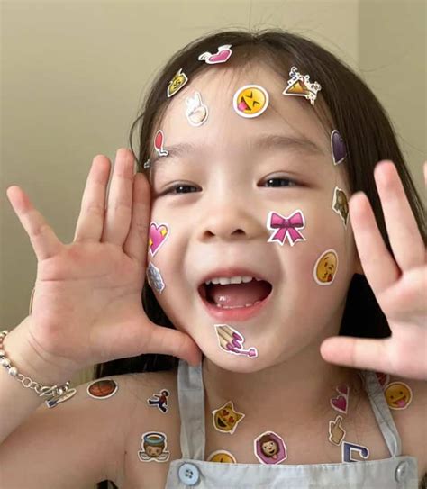脸上胳膊上贴满emoji表情贴纸的可爱女孩头像 真实小女孩照片女生头像图