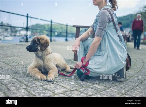 A Young Woman Is Sitting In The Street In A Small Village With Her