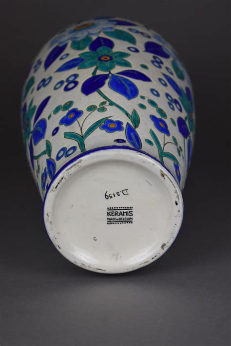 KERAMIS Vase fuselé en faïence à décor émaillé de fleurs dans les camaïeux de bleu et jaune sur