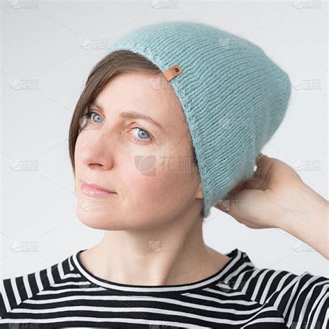 漂亮的年轻女子戴着一顶带绒球的帽子