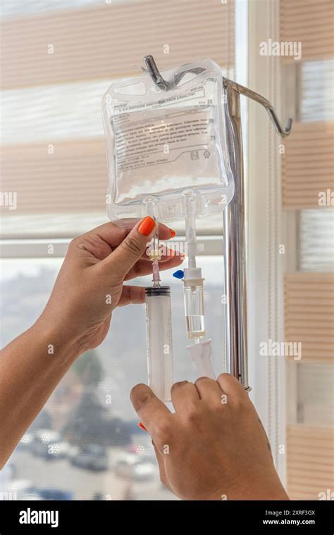 Nurse Connecting An Iv Drip Nurse Preparing And Regulating Infusion