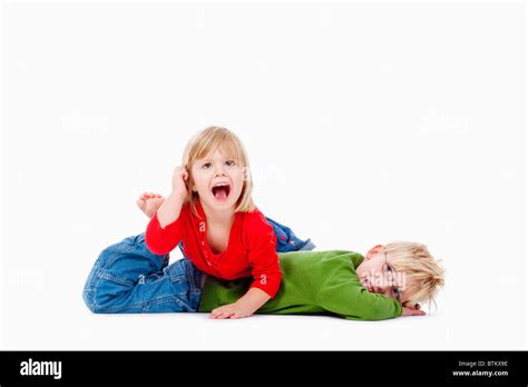 Two Young Siblings Fooling Around With Each Other Isolated On White