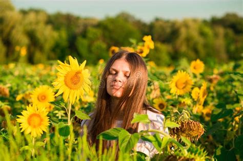 Happy Joyful Girl With Sunflower Enjoying Nature And Laughing Stock