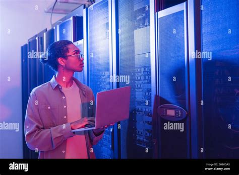 african american programmer with digital tablet working in data center