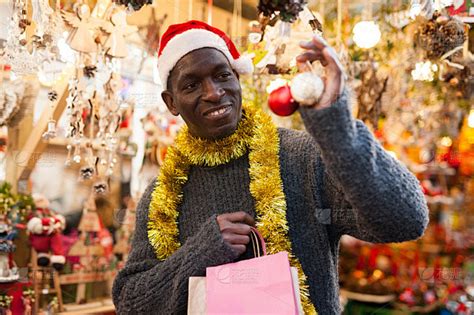 戴着圣诞帽的男人在寻找新年装饰品