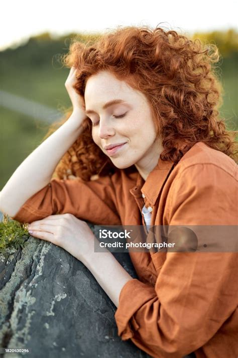 Redhead Curly Woman Is Lying On Large Rock At High Altitude View Of