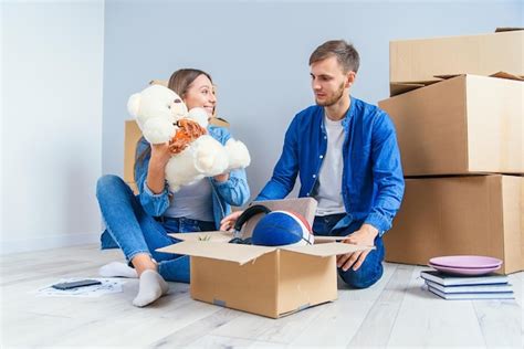 Premium Photo Young Couple Unpacking Things After Moving Into New House