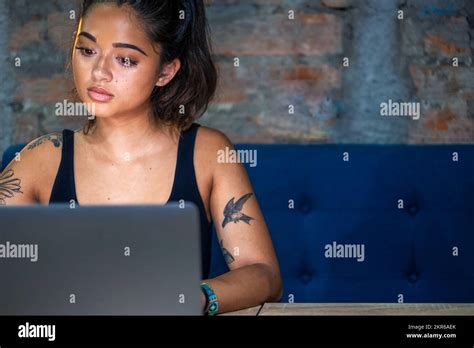 Female Digital Nomad Working On Laptop In Contemporary Coworking Space