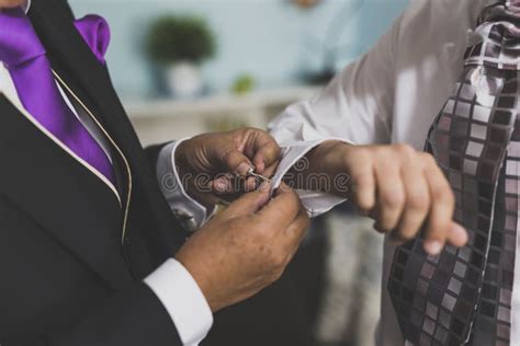 Hombre Ayudando A Otro Hombre A Ponerse Tajos Imagen De Archivo Imagen De Interruptor Metal