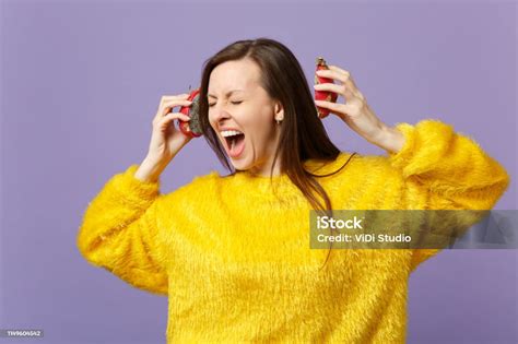 모피 스웨터에 비명 소녀는 눈을 폐쇄 유지 보라색 파스텔 배경에 고립 된 귀 근처 피타 야 용 과일의 Halfs를 개최 합니다 사람들은 생생한 라이프 스타일 휴식 휴가