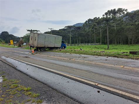Caminhão sai de pista e colide contra mureta de concreto e defensa