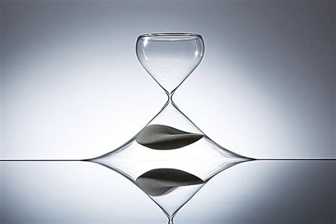An Hourglass Sitting On A Reflective Surface Background Lucky