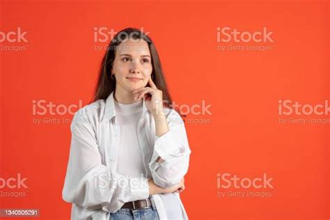 빨간 스튜디오 배경에 고립 된 캐주얼 한 옷을 입은 어린 아름다운 소녀의 자른 초상화 사려 깊은 얼굴 표정 20 24세에 대한 스톡 사진 및 기타 이미지 Istock