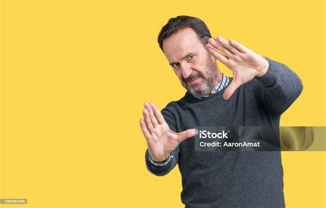 잘생긴 중 년 수석 남자 격리에 스웨터를 입고 미소 하 고 손 손바닥 및 손가락 카메라 관점을 사용 하 여 프레임 배경 개념에