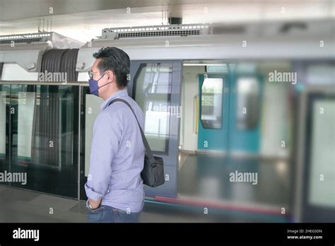 Asian Man Commuter With Face Mask On Walking Out From Subway Train To