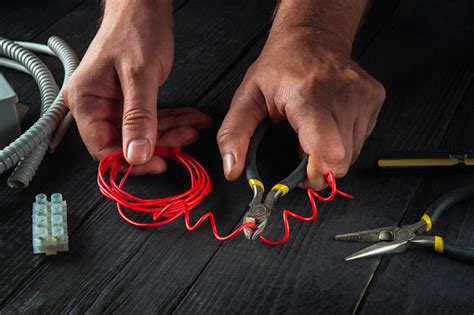 전문 마스터 전기 기술자의 작업장에서 전기 장비 수리 작업하거나 빨간색 와이어를 절단하는 동안 전기 감독의 손을 클로즈업합니다 개체 그룹에 대한 스톡 사진 및 기타 이미지