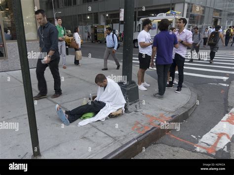 Homeless People Sitting On The Sidewalk Begging Is A Common Sight In