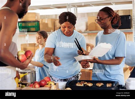 Friendly Black Women Happily Serving Free Food To The Poor And Needy