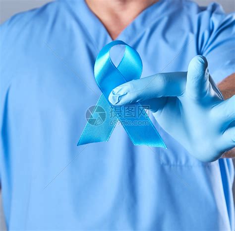 身穿制服和乳胶手套的医生握蓝丝带象征前列腺癌的抗争和治疗高清图片下载 正版图片307099750 摄图网