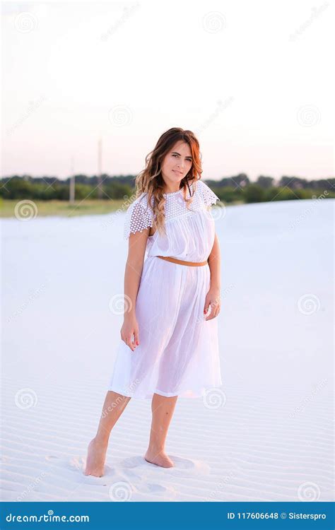 Beautiful Girl Wearing White Dress Walking Barefoot On Sand Stock