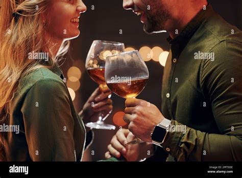 Standing And Holding Big Glasses With Wine Young Lovely Couple Have